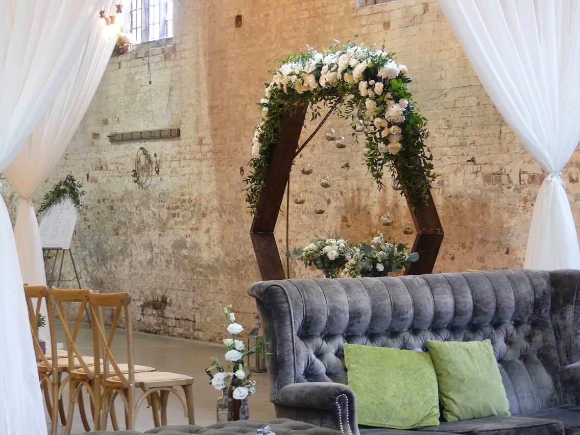 Wood Hexagon backdrop 7ft with silk flowers - Inspired Hire